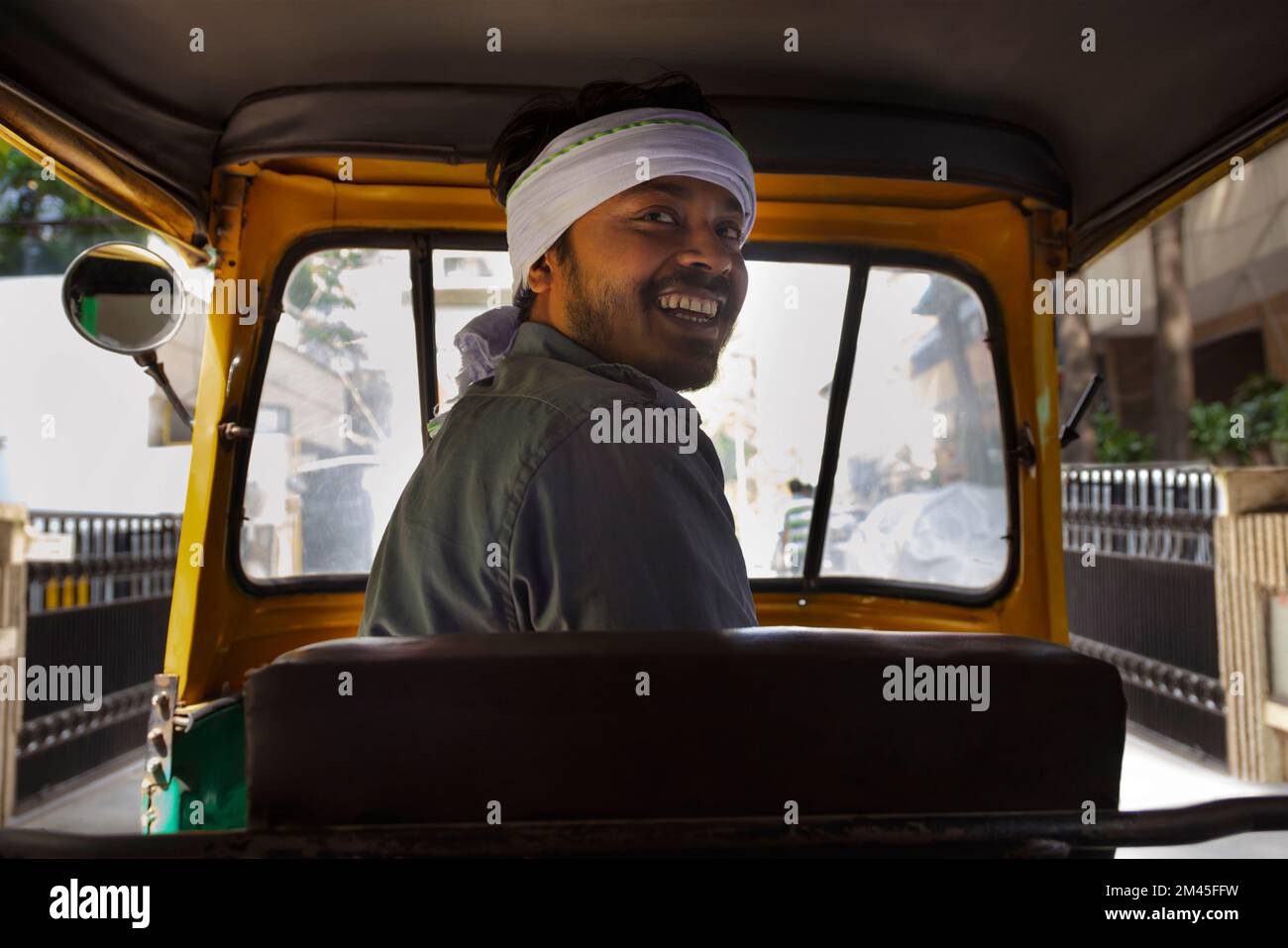 Portrait of a happy auto rickshaw driver looking back Stock Photo - Alamy