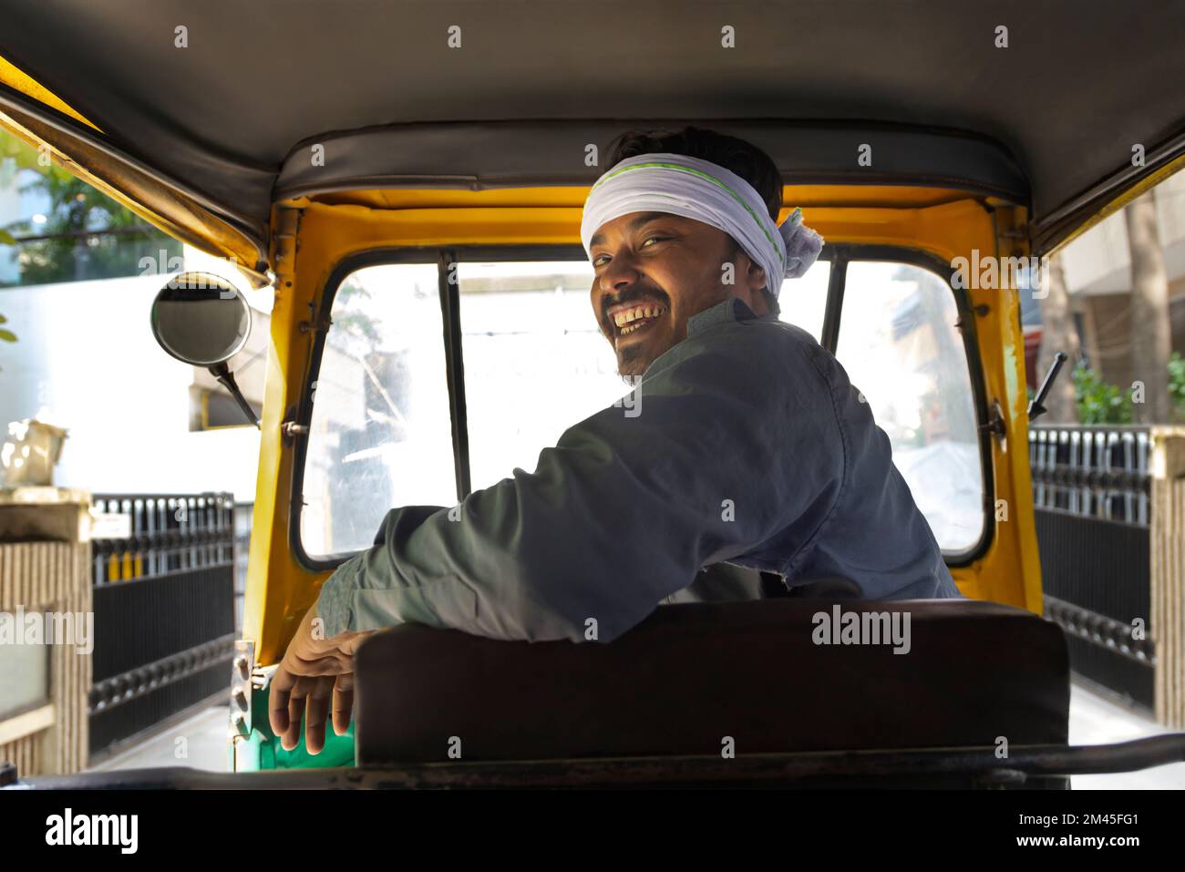 Portrait of a happy auto rickshaw driver looking back Stock Photo - Alamy