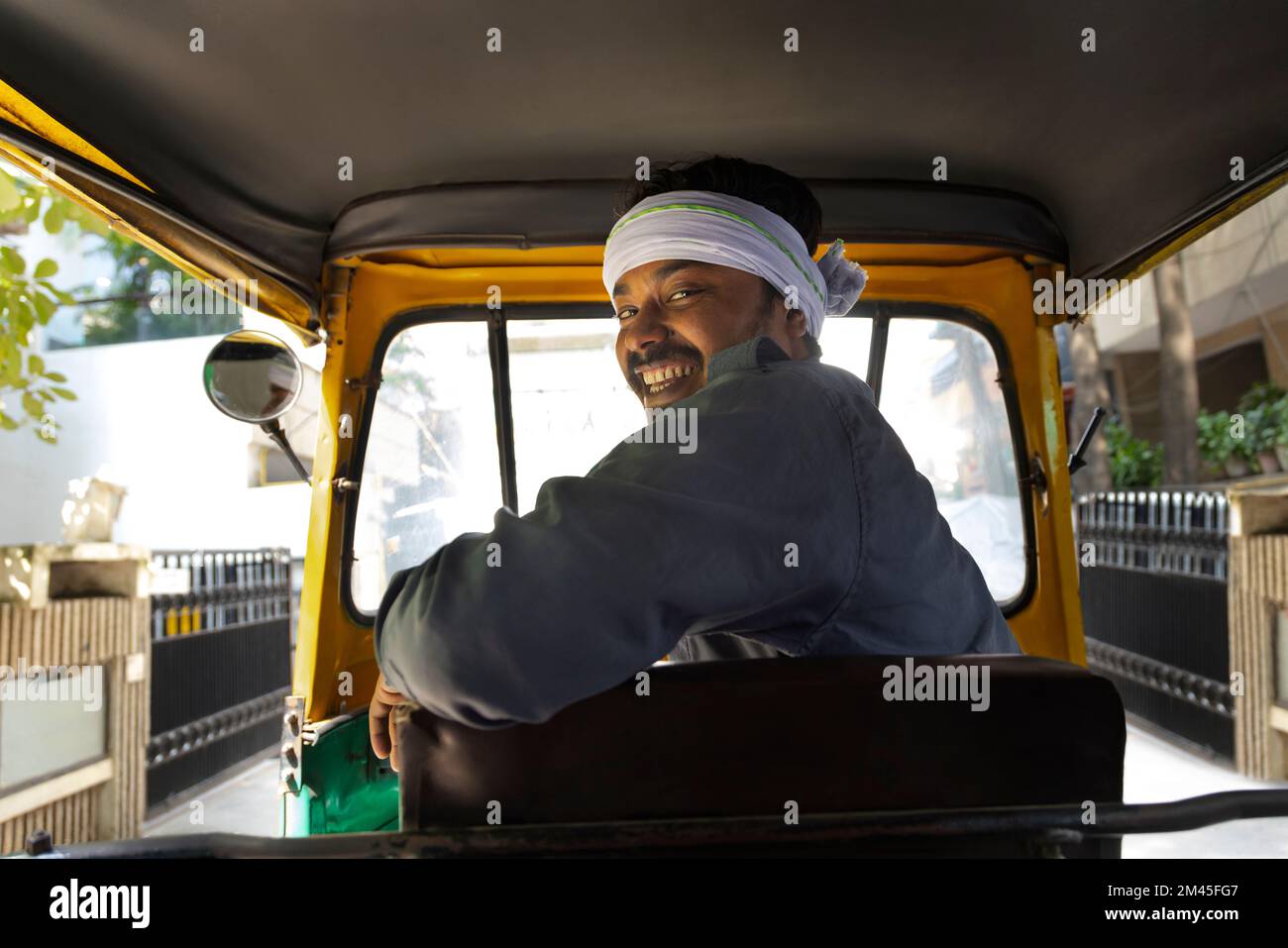 Portrait of a happy auto rickshaw driver looking back Stock Photo - Alamy