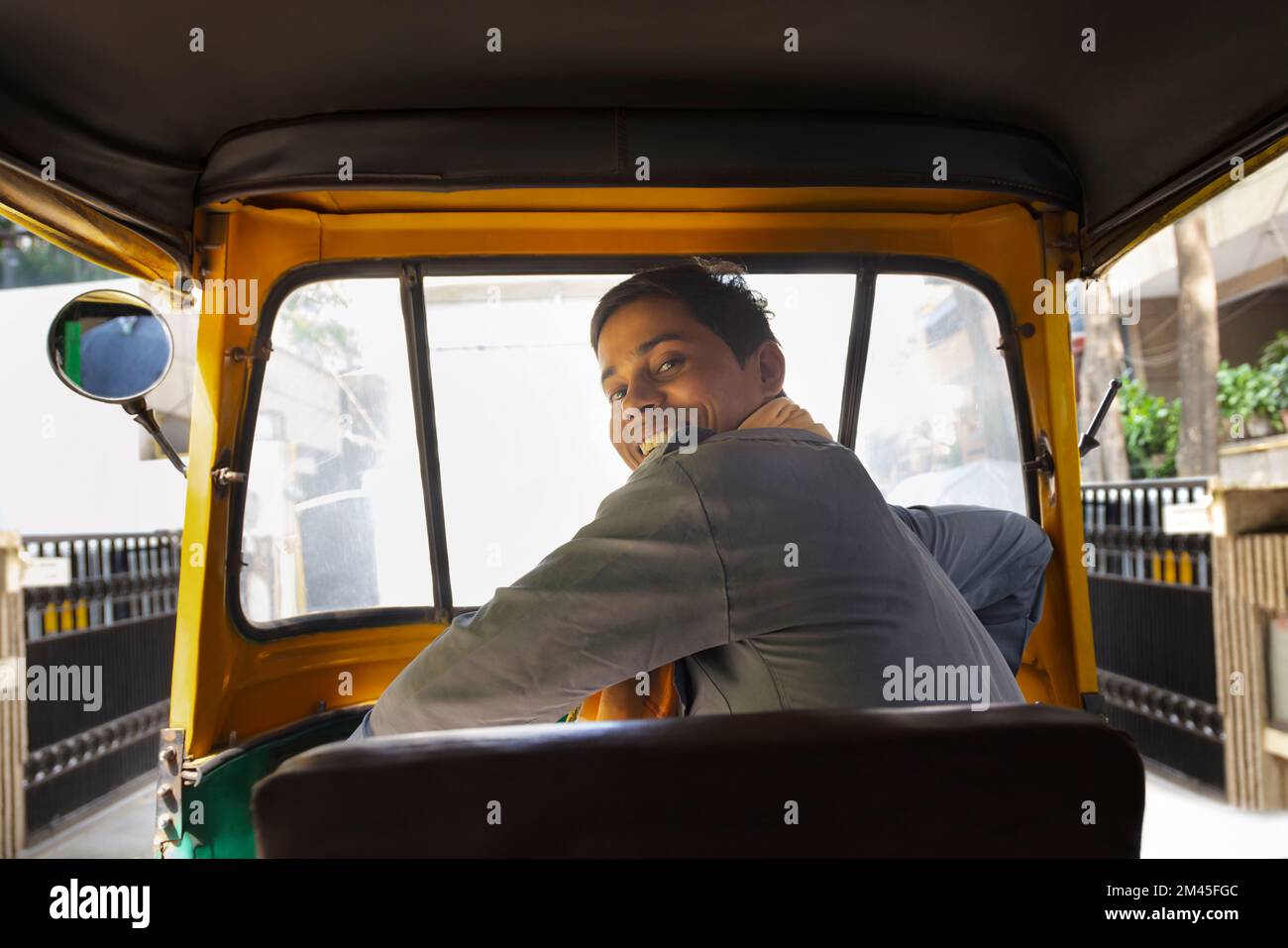 Portrait of a happy auto rickshaw driver looking back Stock Photo - Alamy