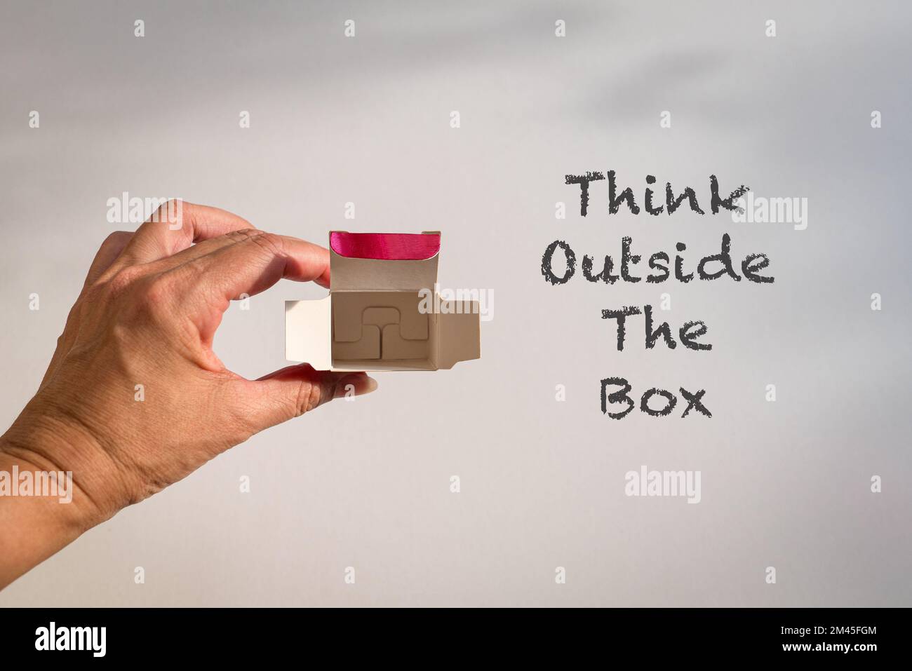 Word, Think outside the box next to fingers holding an open small box ...