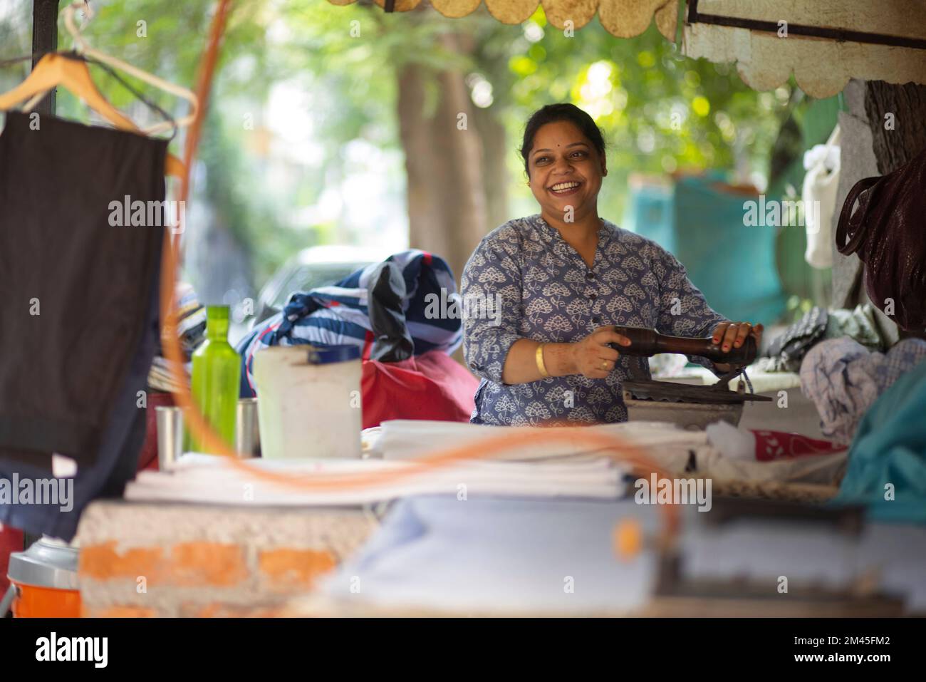 A woman Dhobi ironing clothes with an old coal heated iron Stock Photo ...