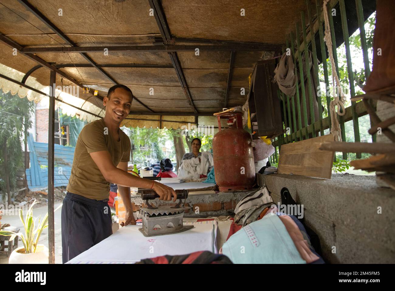 Indian Man, Dhobi, ironing clothes outside a colony for its residents ...