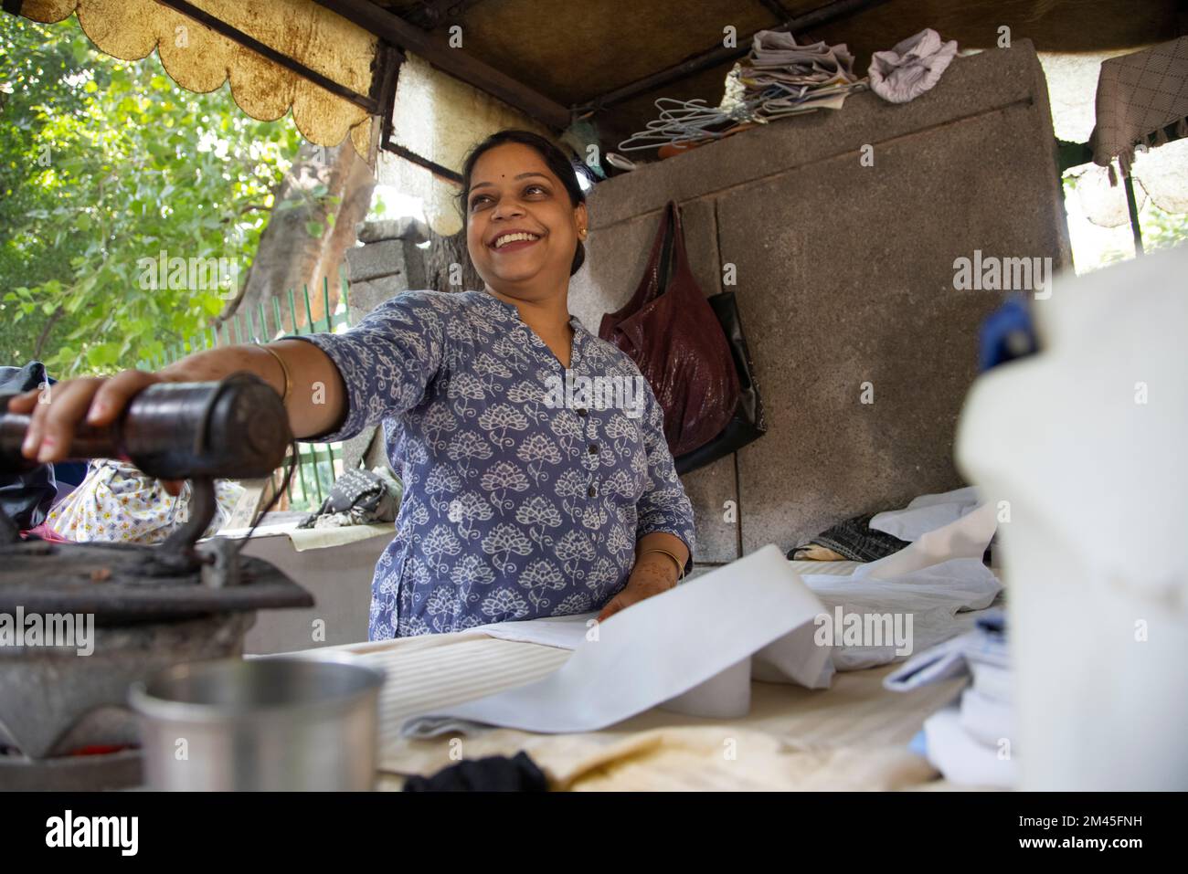 A woman Dhobi ironing clothes with an old coal heated iron Stock Photo ...