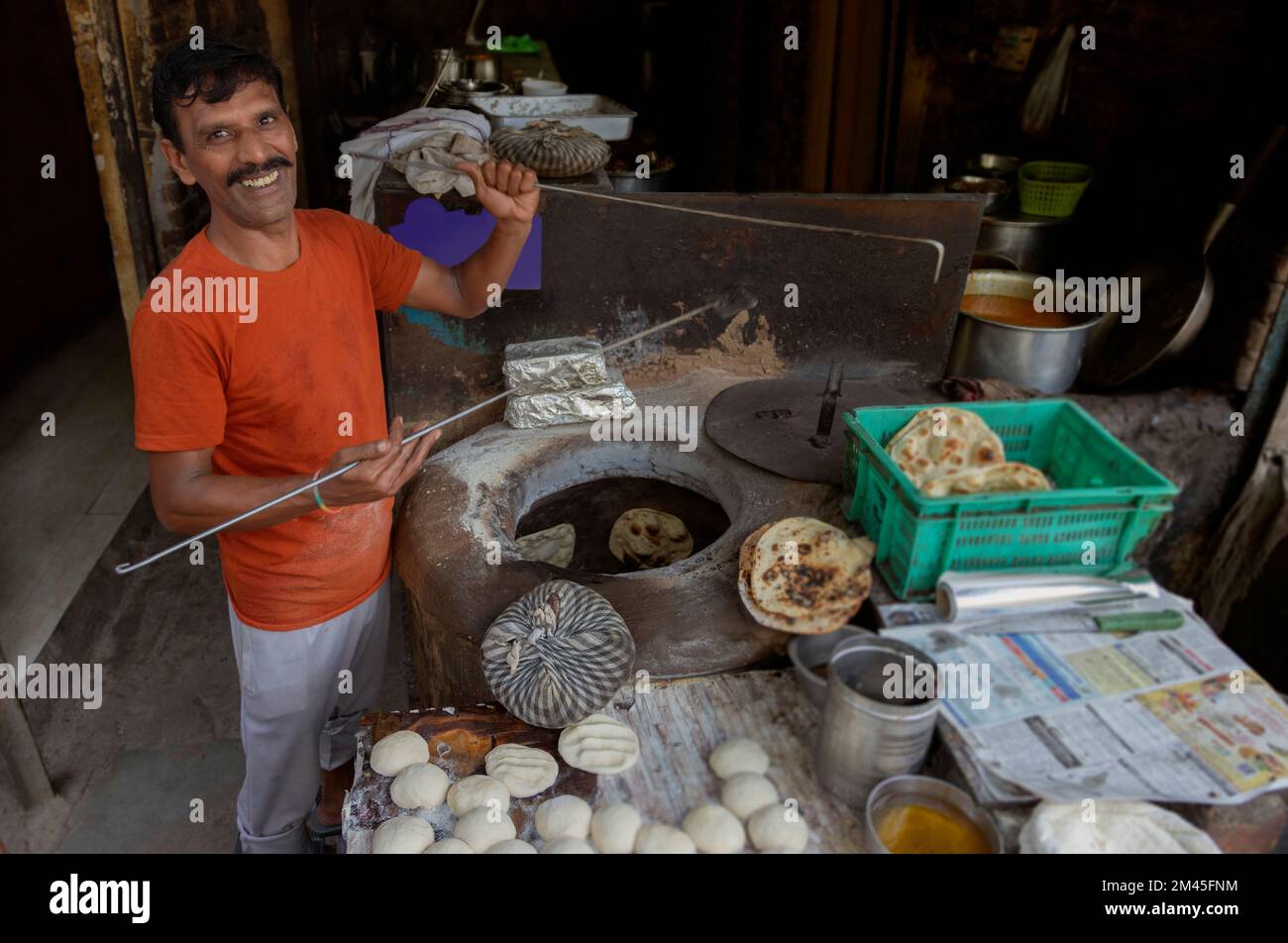 Cook of a local roadside restaurant or a dhaba, making bread or a roti ...