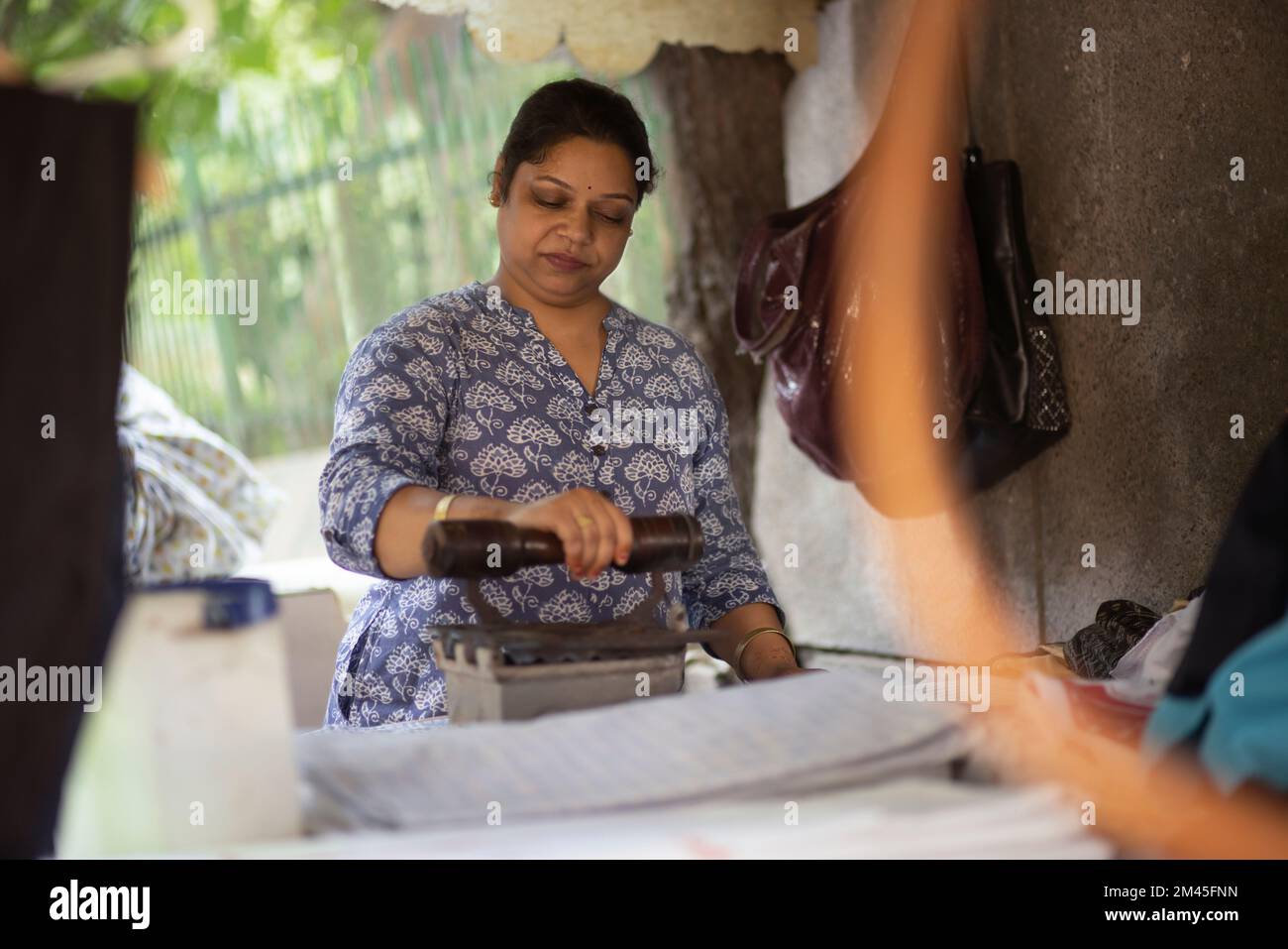A woman Dhobi ironing clothes with an old coal heated iron Stock Photo ...