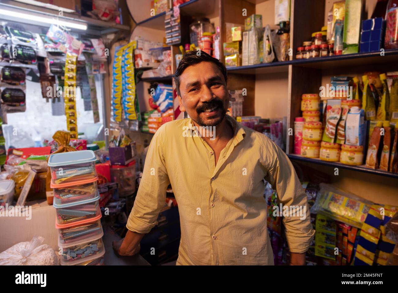 Portrait of the owner of a grocery store standing in front of the ...