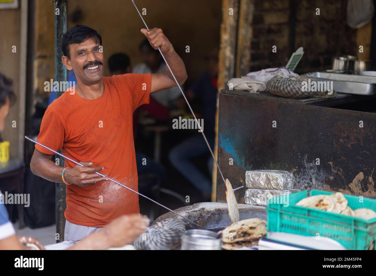 Cook of a local roadside restaurant or a dhaba, making bread or a roti ...