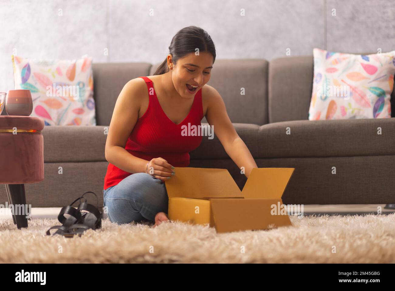 Excited teenage girl unpacking shoes from cardboard box after online ...