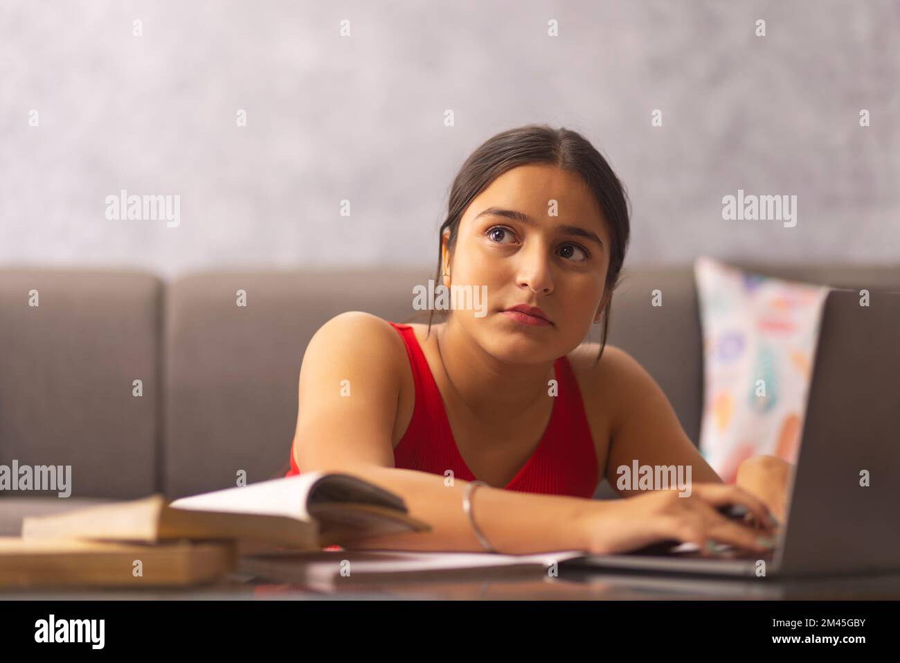 Portrait of a teenage girl doing homework during online classes Stock ...