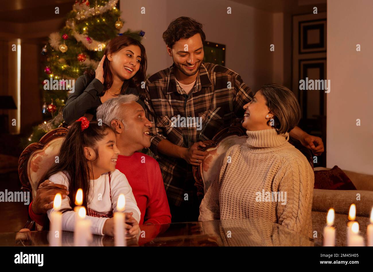 Happy family celebrating Christmas together in living room Stock Photo ...
