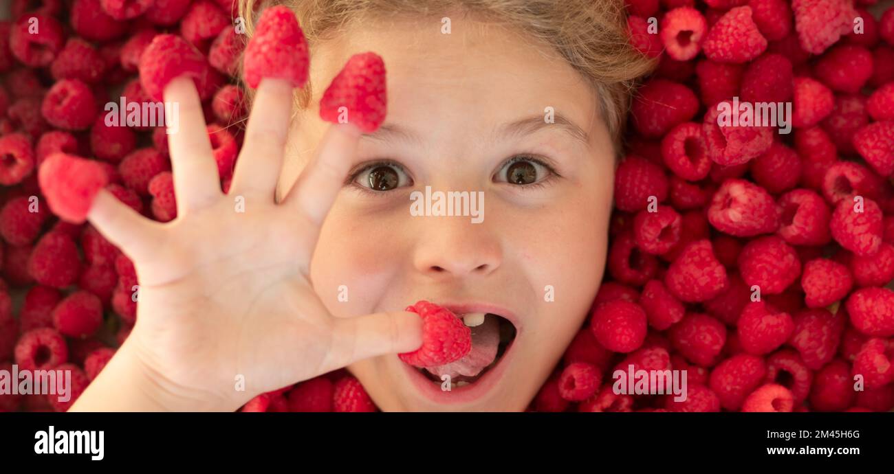 Funny excited kids face near raspberry background, close up studio ...