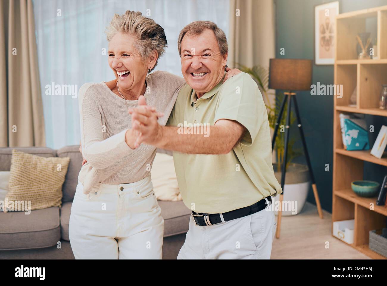 Happy, dance and senior couple in a living room, smile and fun while ...