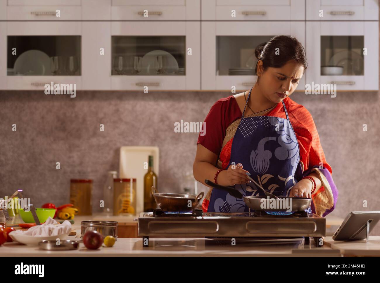 Woman following recipe on tablet while cooking in the kitchen Stock ...