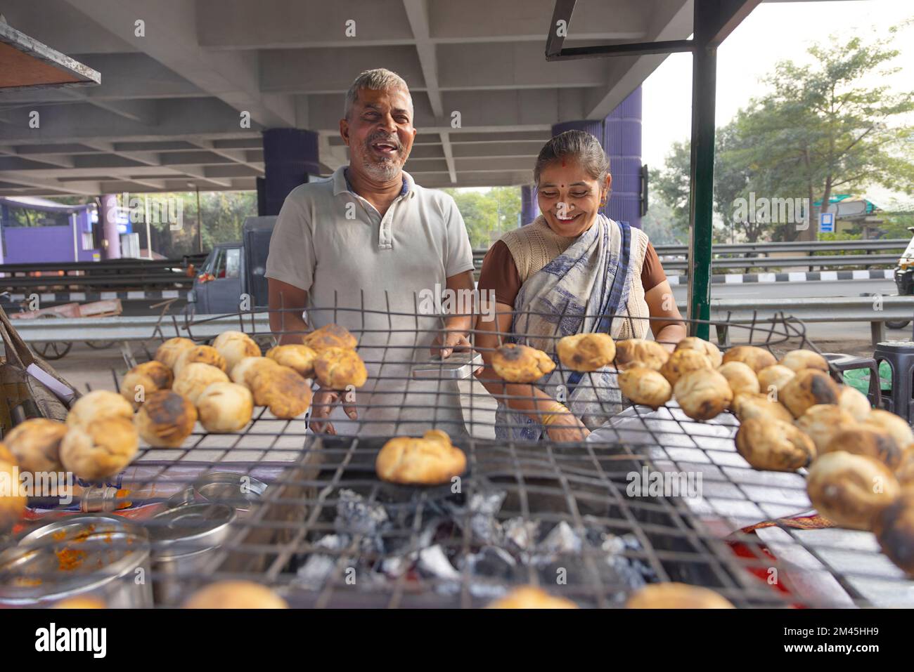 Senior couple making litti at his roadside food stall Stock Photo - Alamy