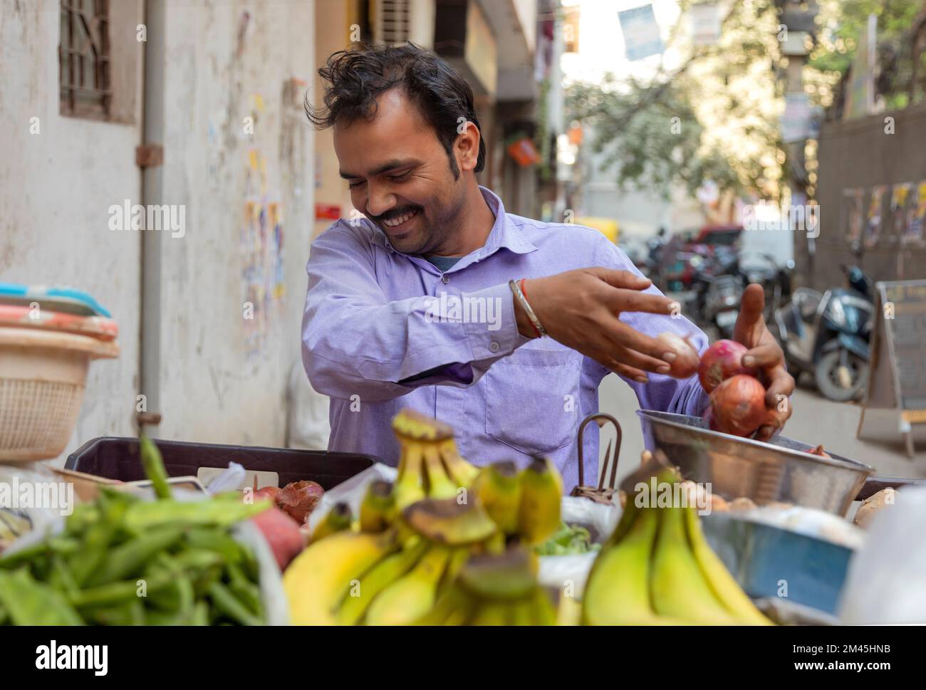 Male vendor selling vegetables at his roadside stall Stock Photo - Alamy