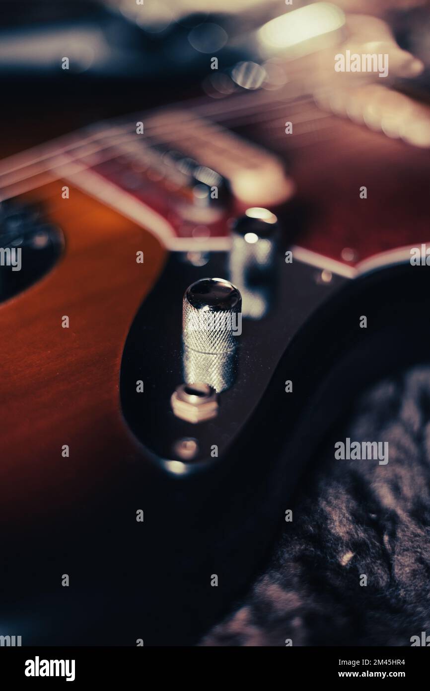 A vertical shot of a modern, brown electric guitar on the ground Stock ...