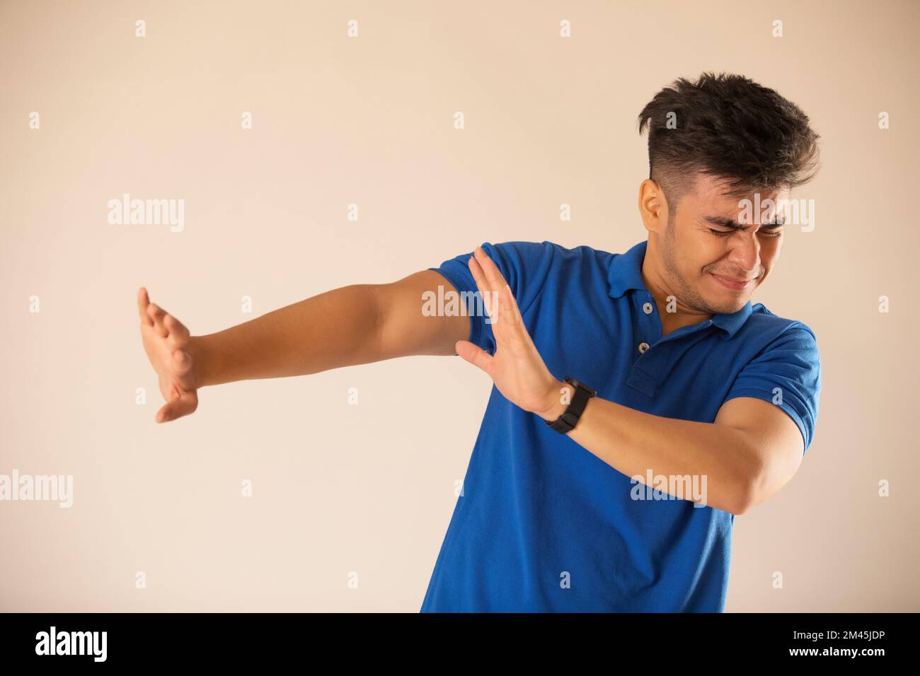 Frustrated young man showing stopping gesture against white background ...