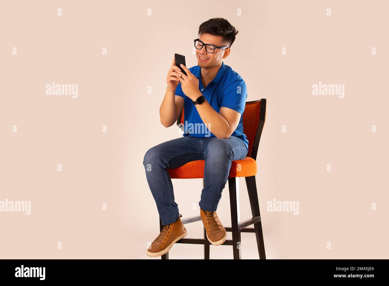 Man sitting on chair looking at phone side view hi-res stock ...