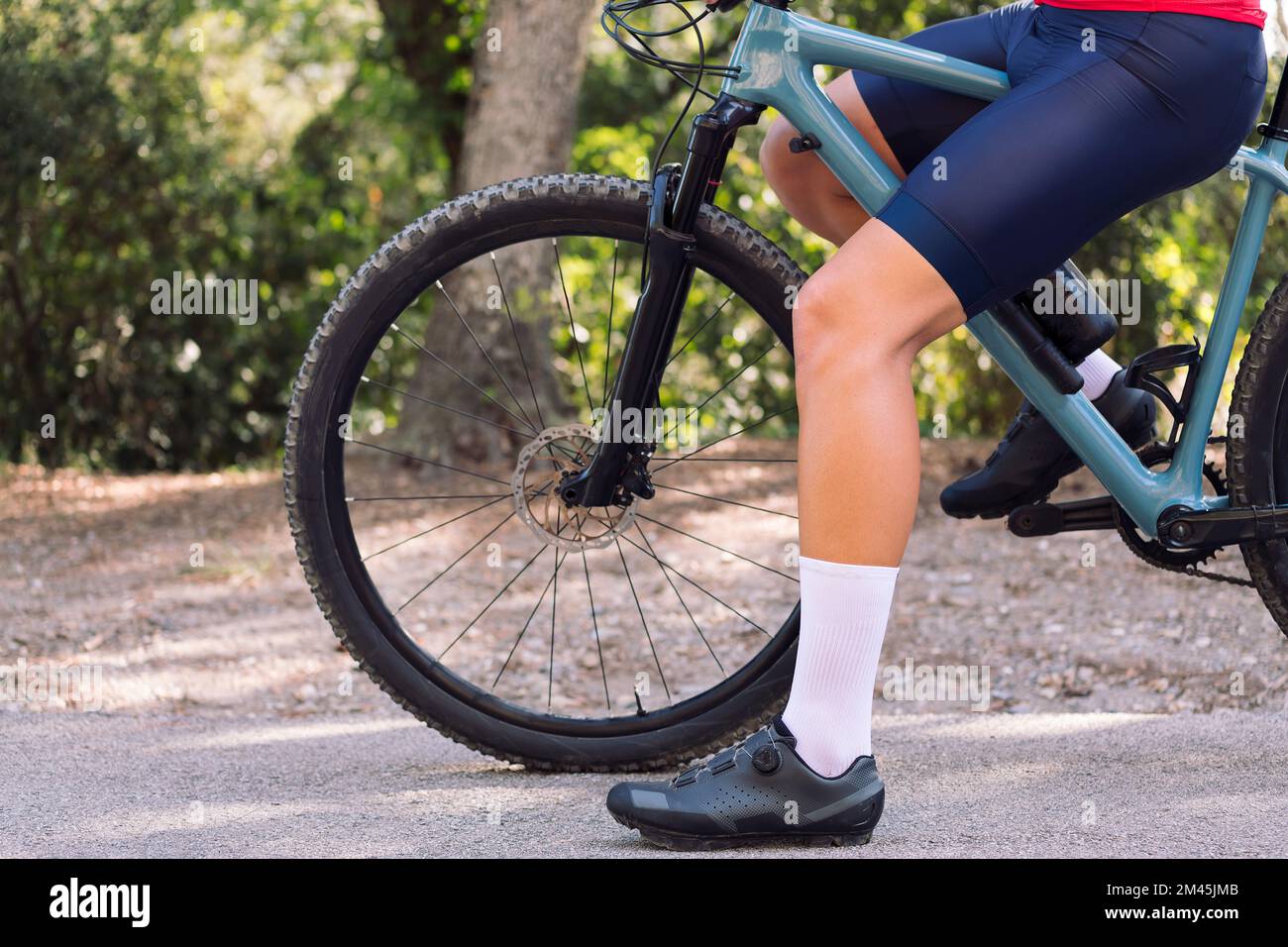 legs of a cyclist resting on his mountain bike Stock Photo - Alamy