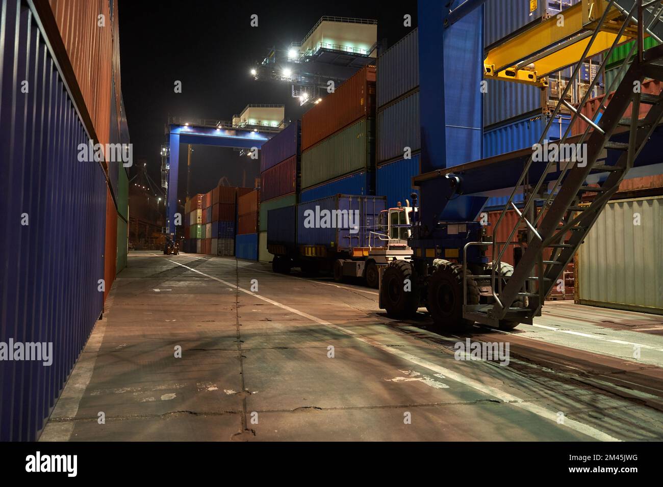 operation of container terminal at night. Unloading container ship at ...