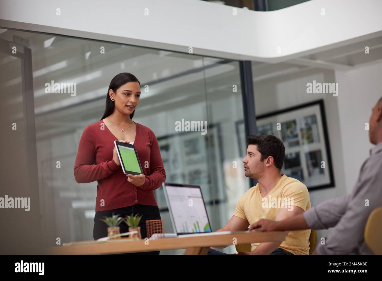 Facilitating meetings with smart apps. a young businesswoman using a ...
