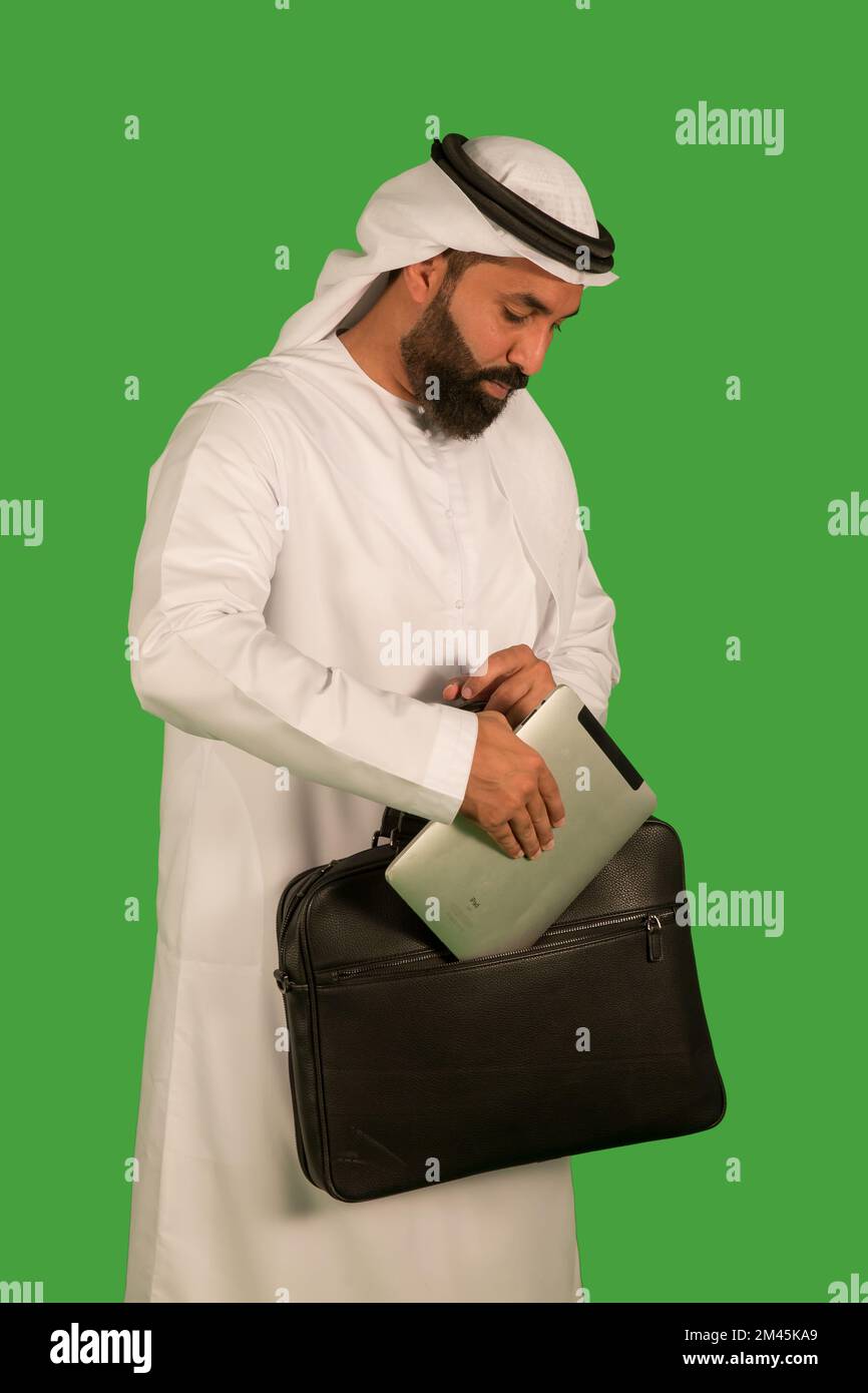 Emirati man pulling out a digital tablet from bag Stock Photo - Alamy