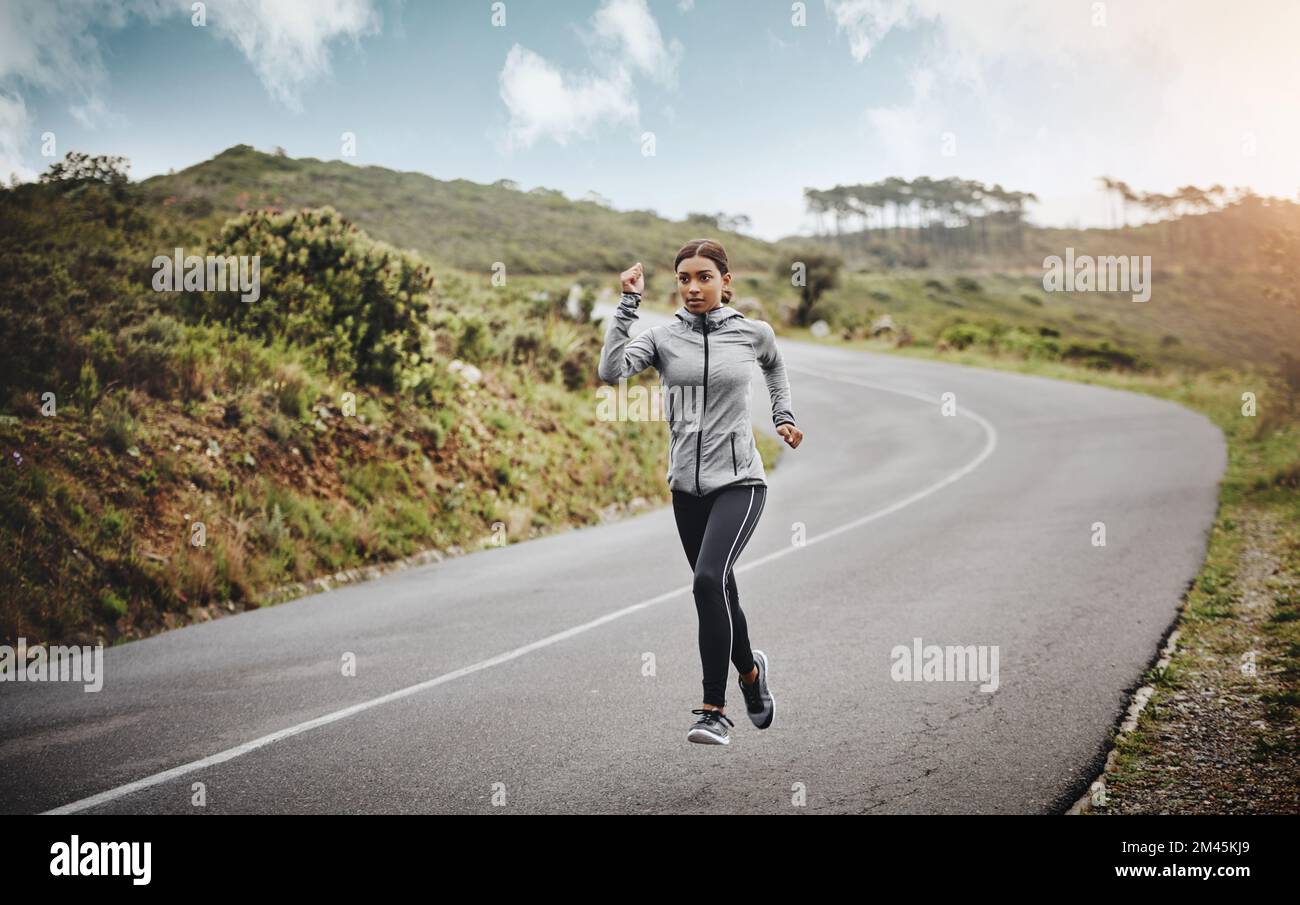 The finish line is so close. a sporty young woman running outdoors ...