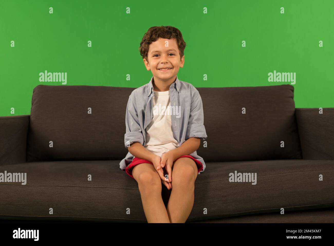 Boy sitting on sofa Stock Photo - Alamy