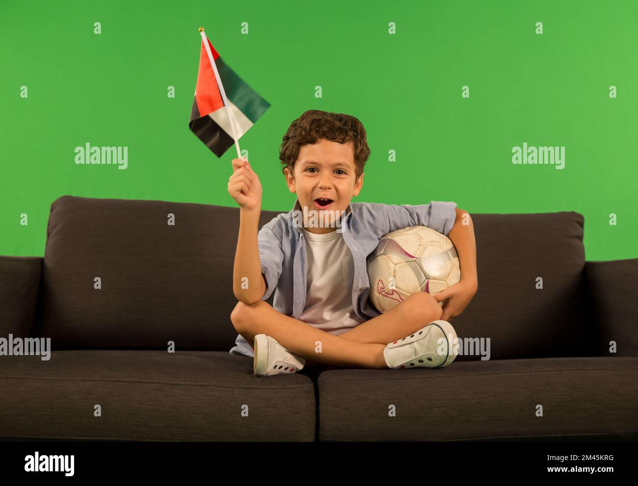 Boy holding a ball and the UAE National flag Stock Photo - Alamy