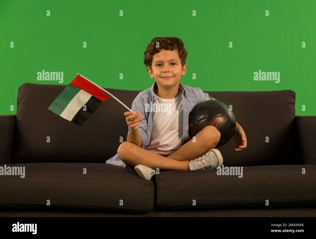 Boy holding a ball and the UAE National flag Stock Photo - Alamy