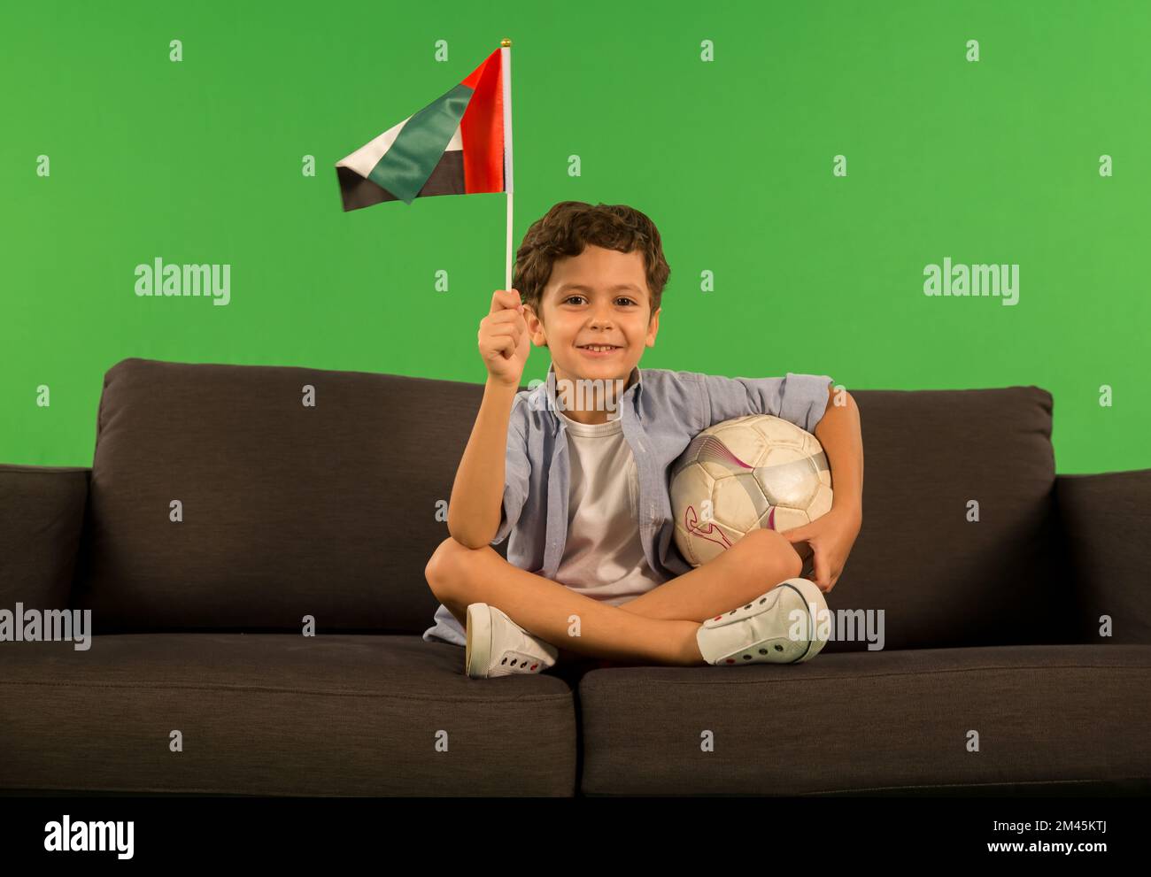 Boy holding a ball and the UAE National flag Stock Photo - Alamy