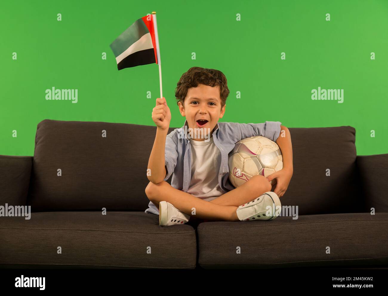 Boy holding a ball and the UAE National flag Stock Photo - Alamy