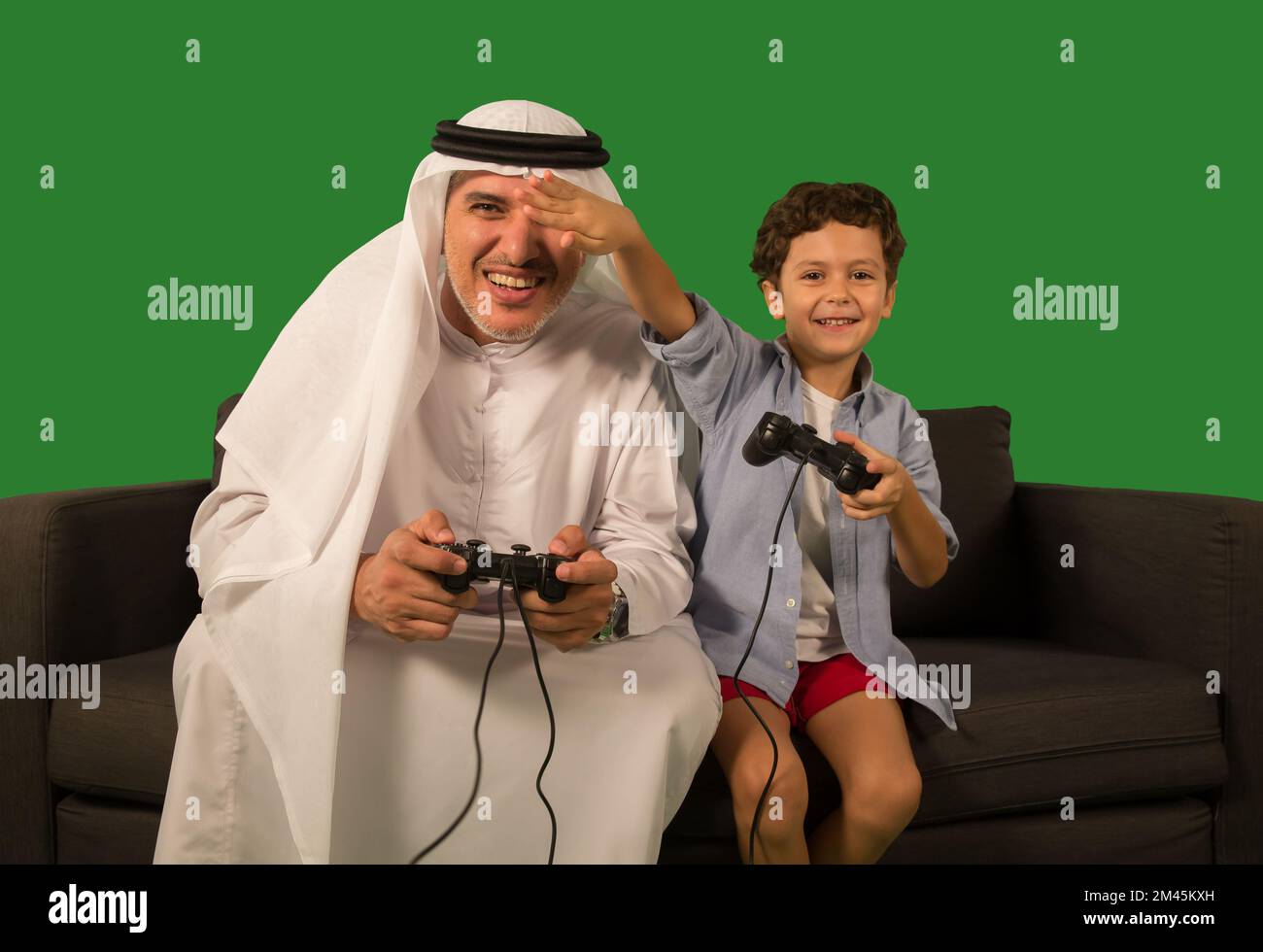 Emirati father with son playing video game Stock Photo - Alamy
