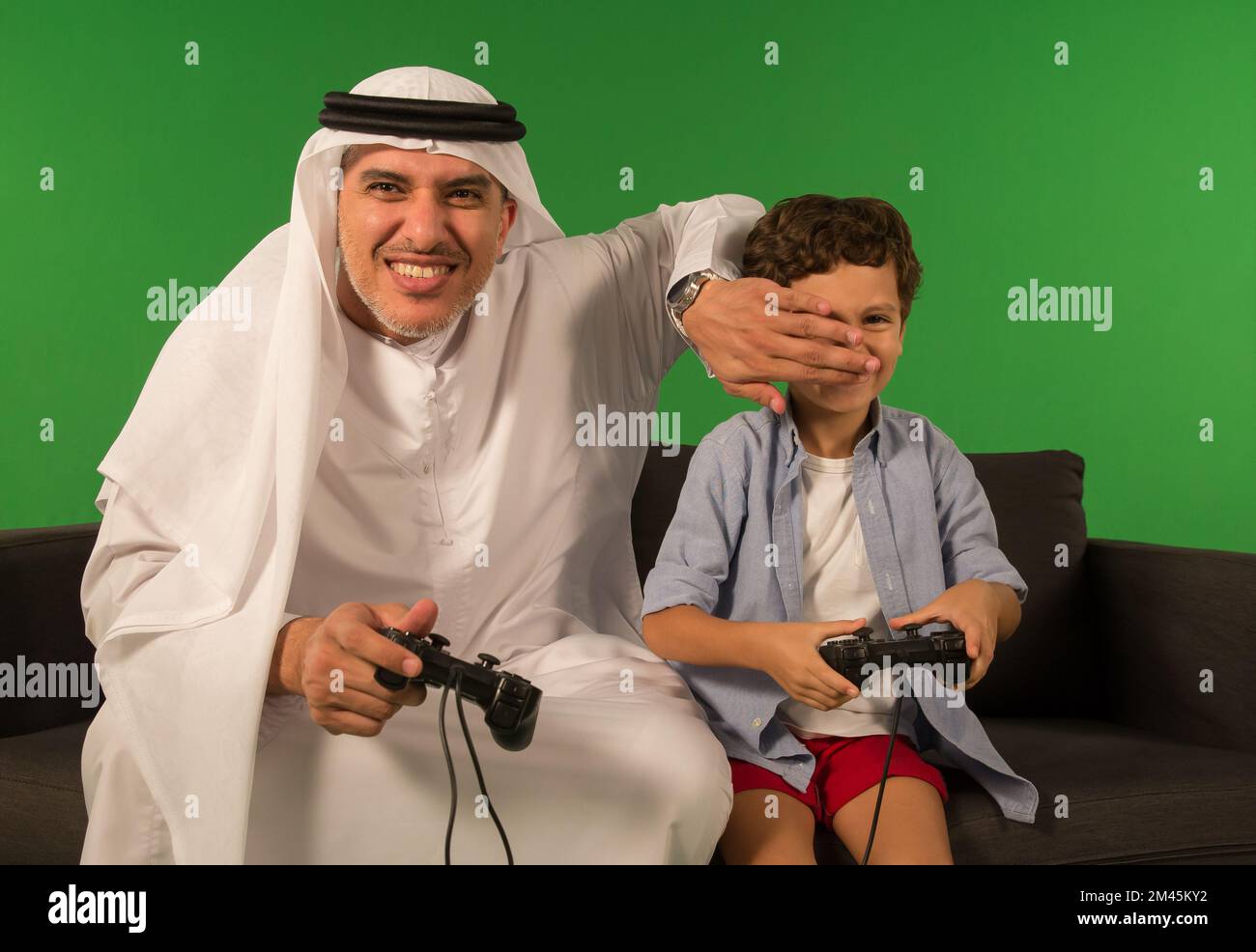 Emirati father with son playing video game Stock Photo - Alamy