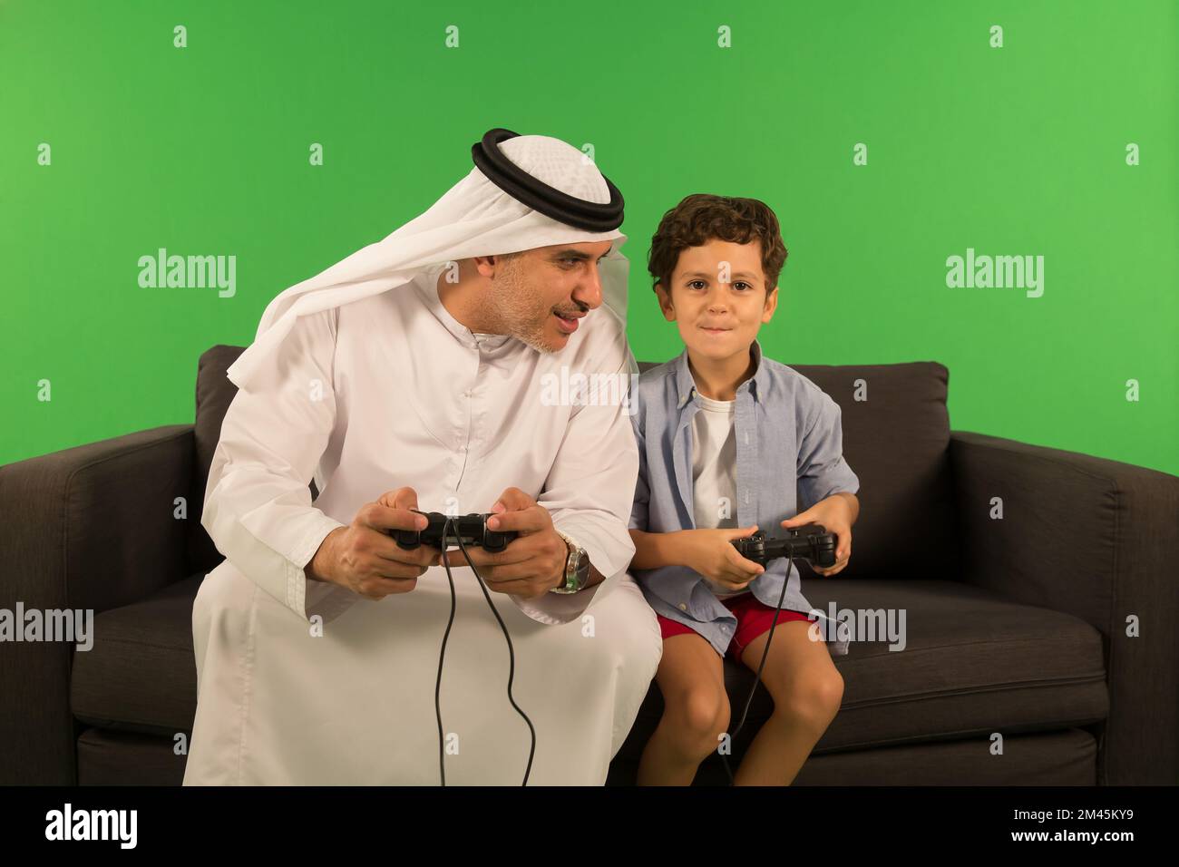 Emirati father with son playing video game Stock Photo - Alamy