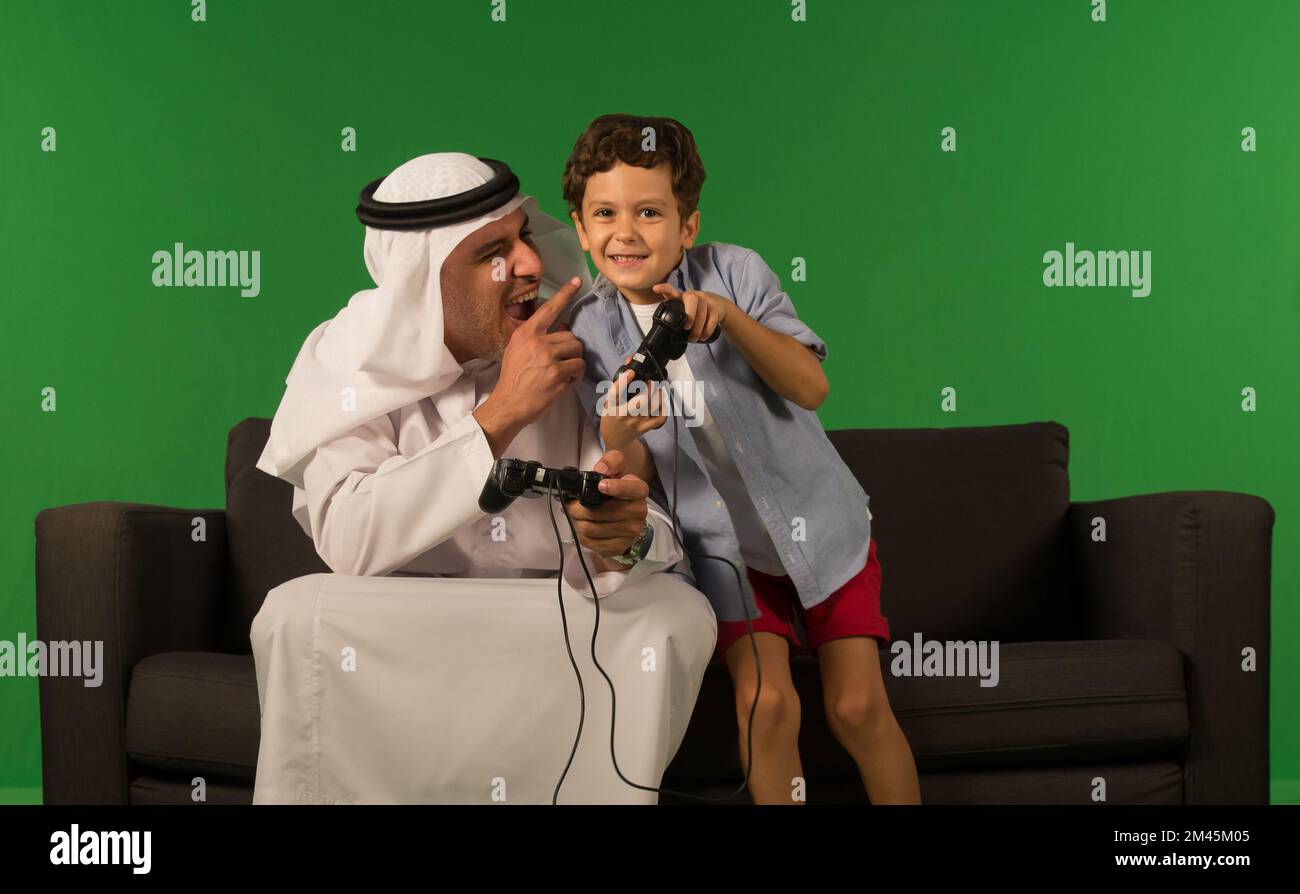 Emirati father with son playing video game Stock Photo - Alamy