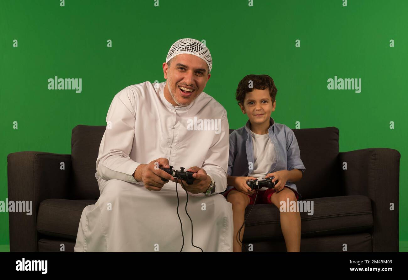 Emirati father with son playing video game Stock Photo - Alamy