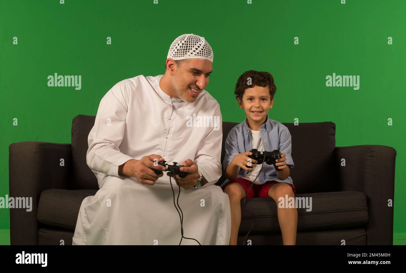 Emirati father with son playing video game Stock Photo - Alamy