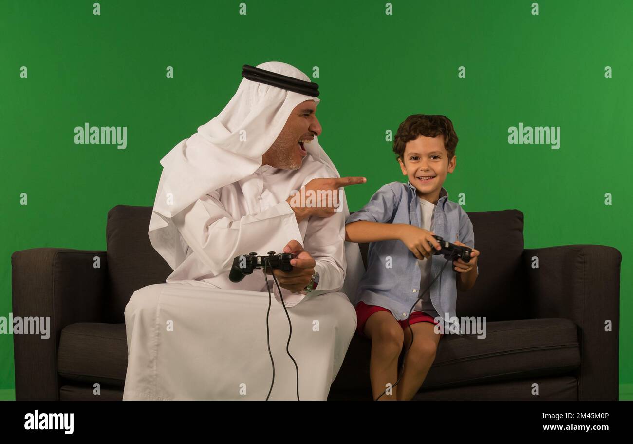 Emirati father with son playing video game Stock Photo - Alamy