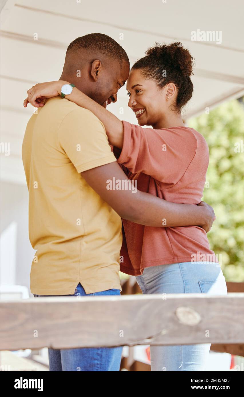 Black couple, love hug and relax in home patio, smiling and bonding ...
