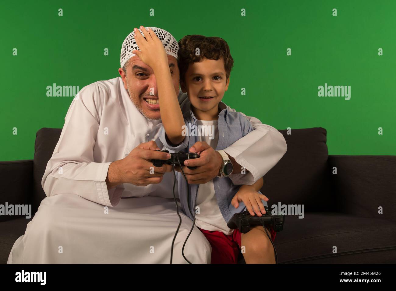 Emirati father with son playing video game Stock Photo - Alamy