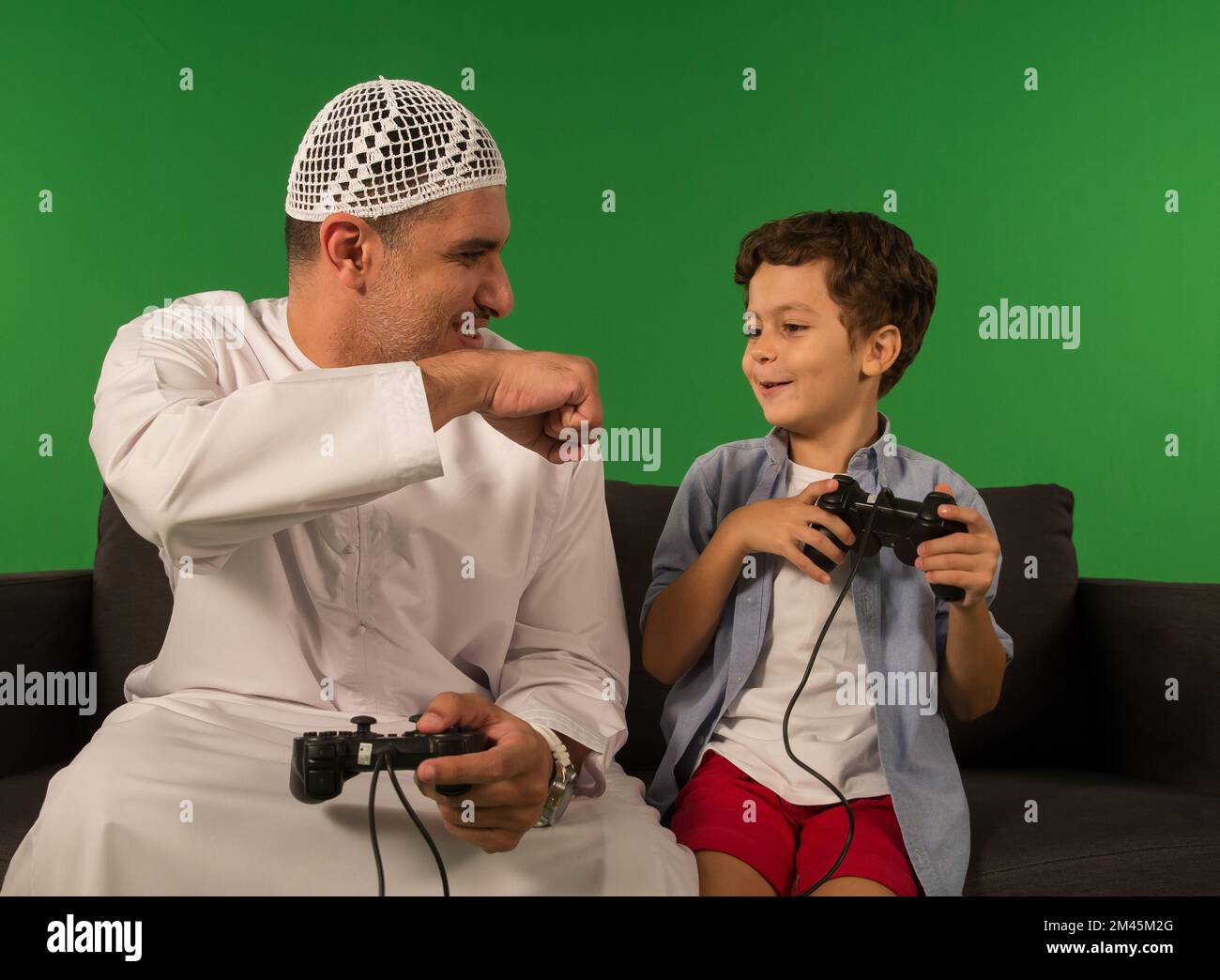 Emirati father with son playing video game Stock Photo - Alamy
