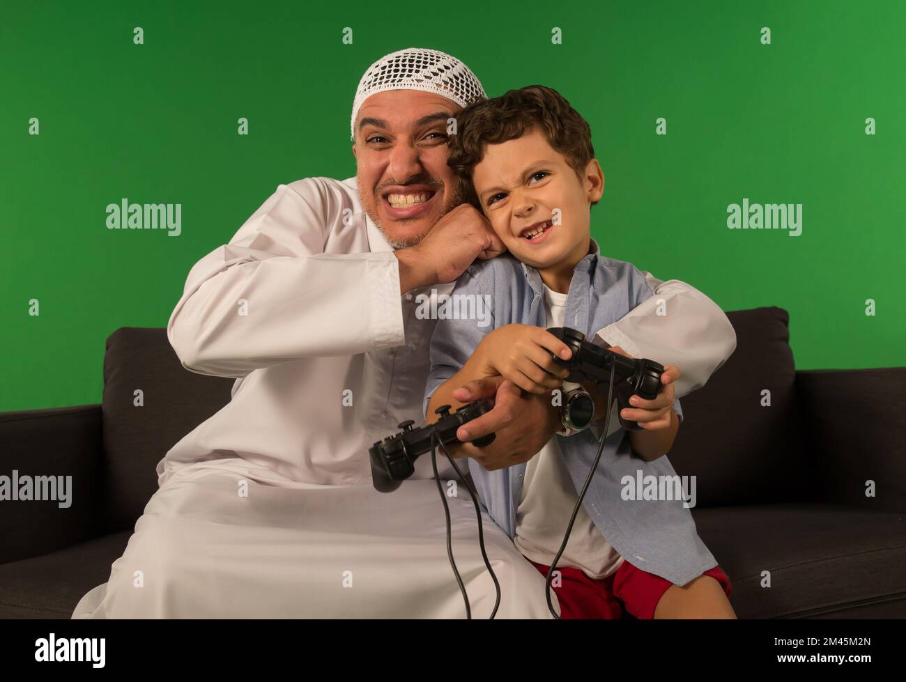 Emirati father with son playing video game Stock Photo - Alamy