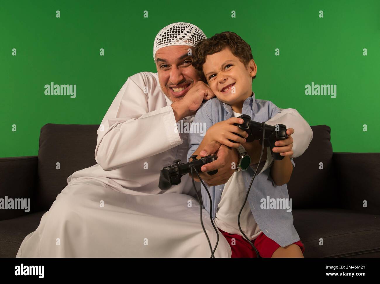 Emirati father with son playing video game Stock Photo - Alamy