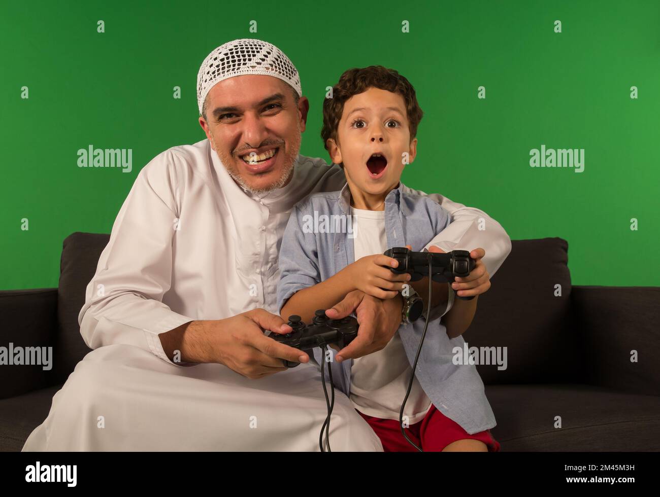 Emirati father with son playing video game Stock Photo - Alamy