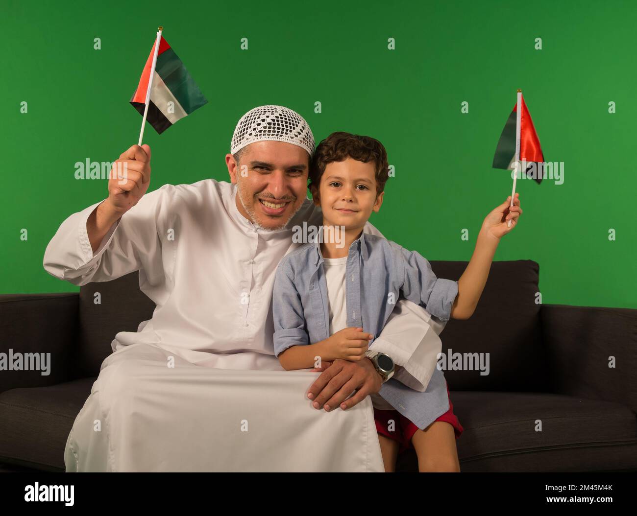 Portrait of father and son waving the UAE national Flag Stock Photo - Alamy