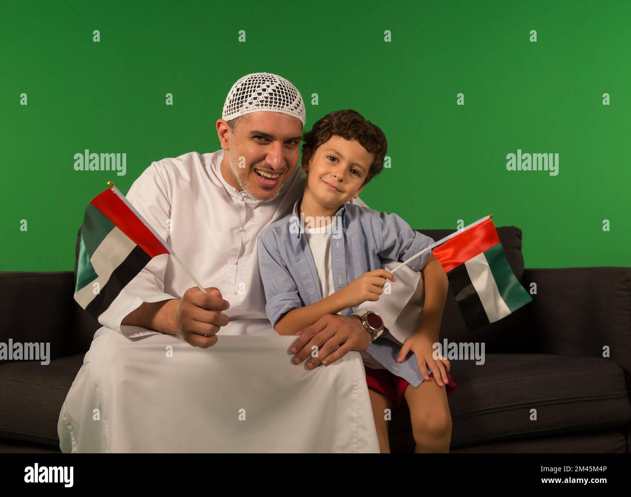 Portrait of father and son waving the UAE national Flag Stock Photo - Alamy