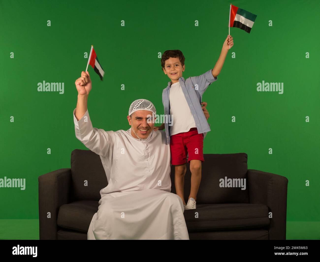 Portrait of father and son waving the UAE national Flag Stock Photo - Alamy