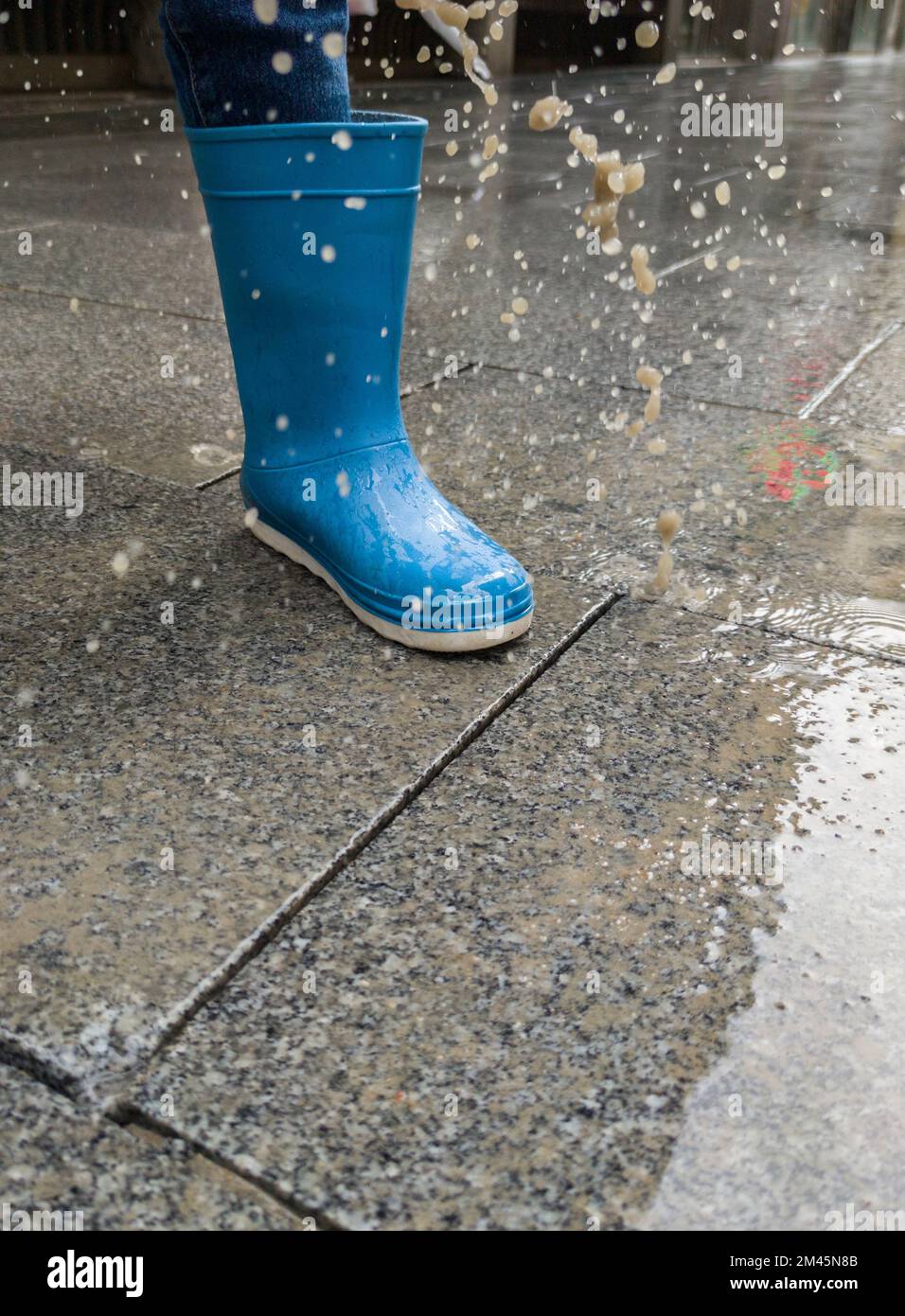 A loose cobblestone splashes on a childs boots when stepped on. High ...